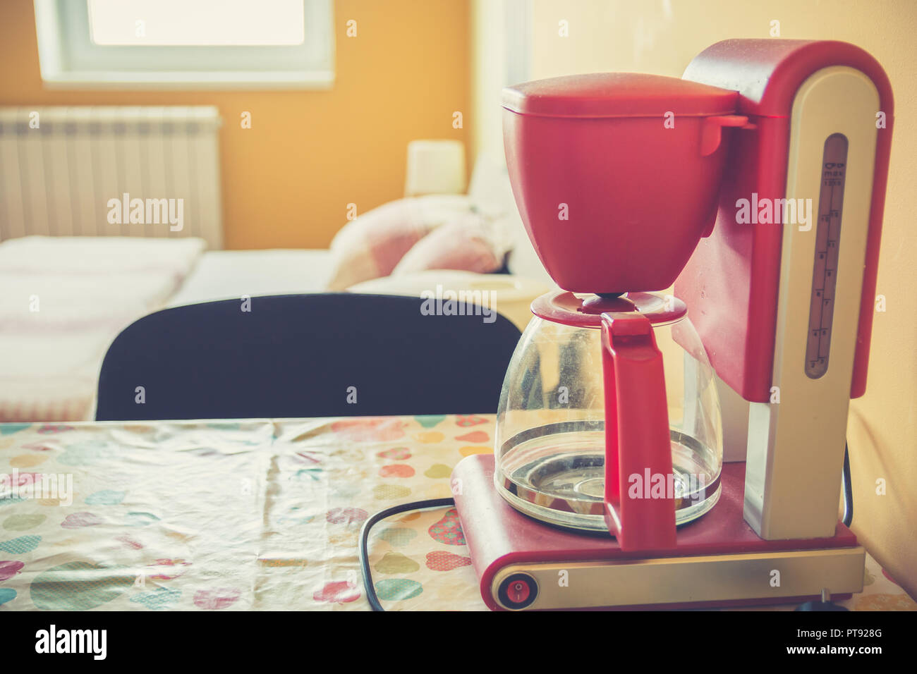 Red coffee maker on the table in hotel room. Close up Stock Photo - Alamy