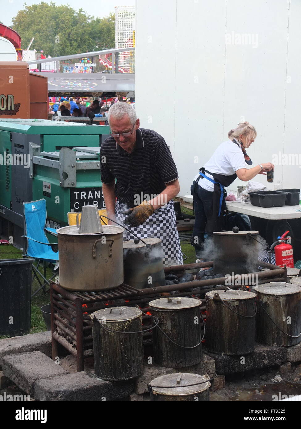 Stallholders prepare boiling pans of mushy peas to sell on a food stall ...