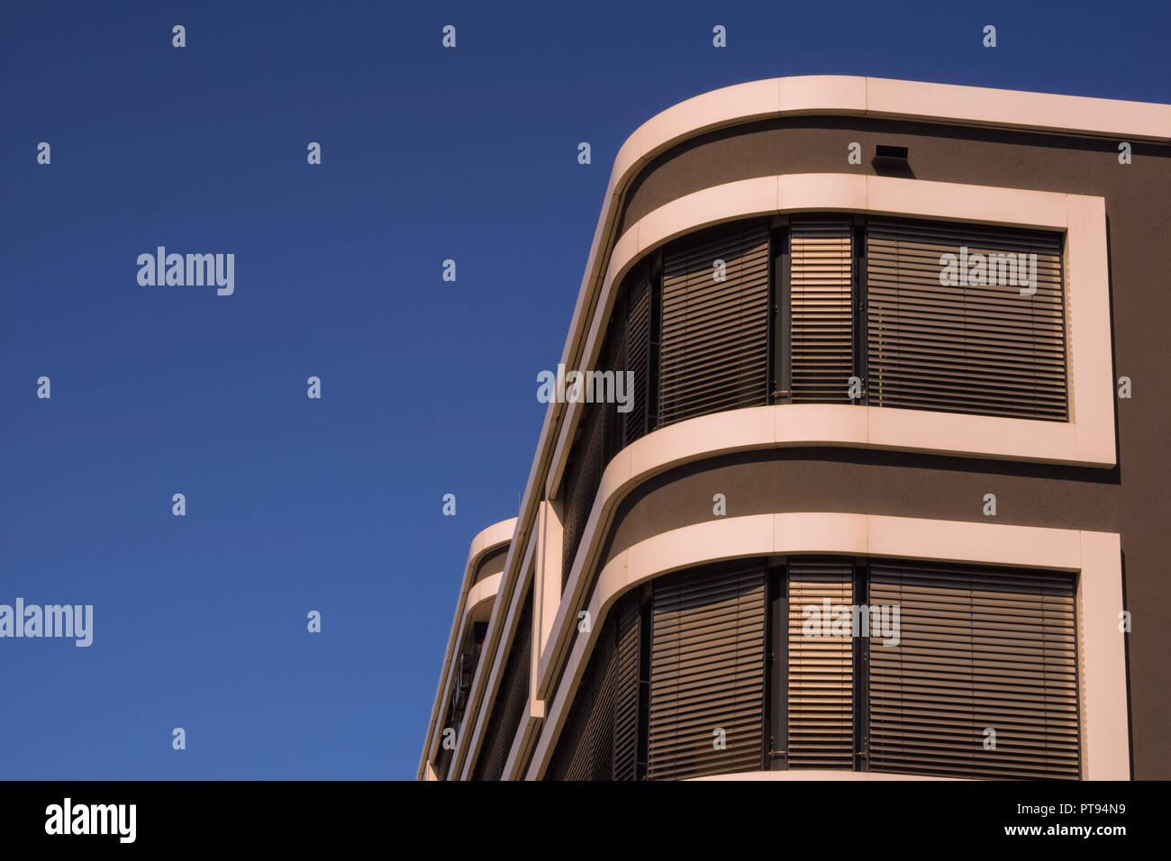 The upper part of a modern building below a blue sky Stock Photo - Alamy