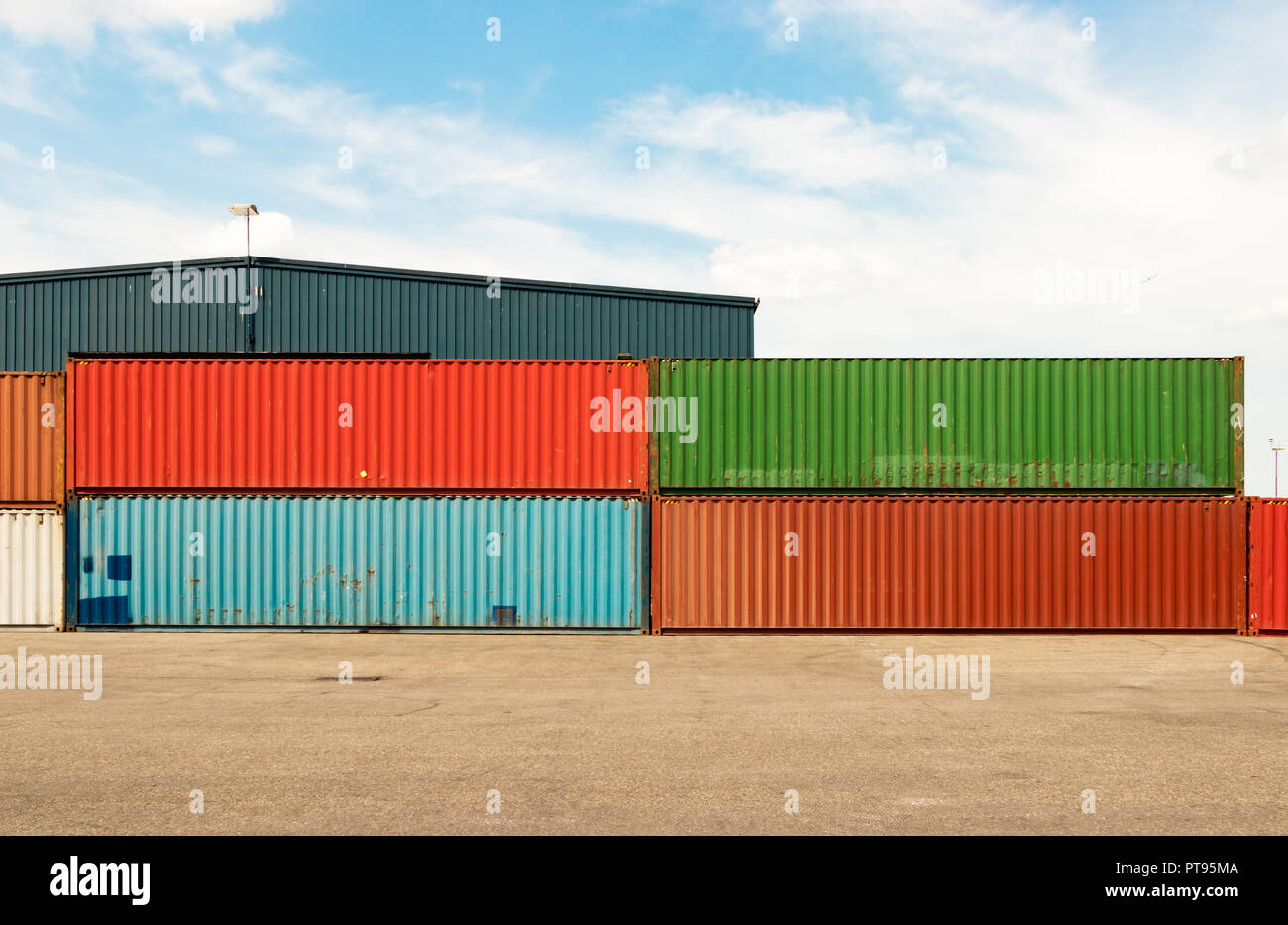 Four shipping containers stacked, rectangular pattern, green, blue and ...