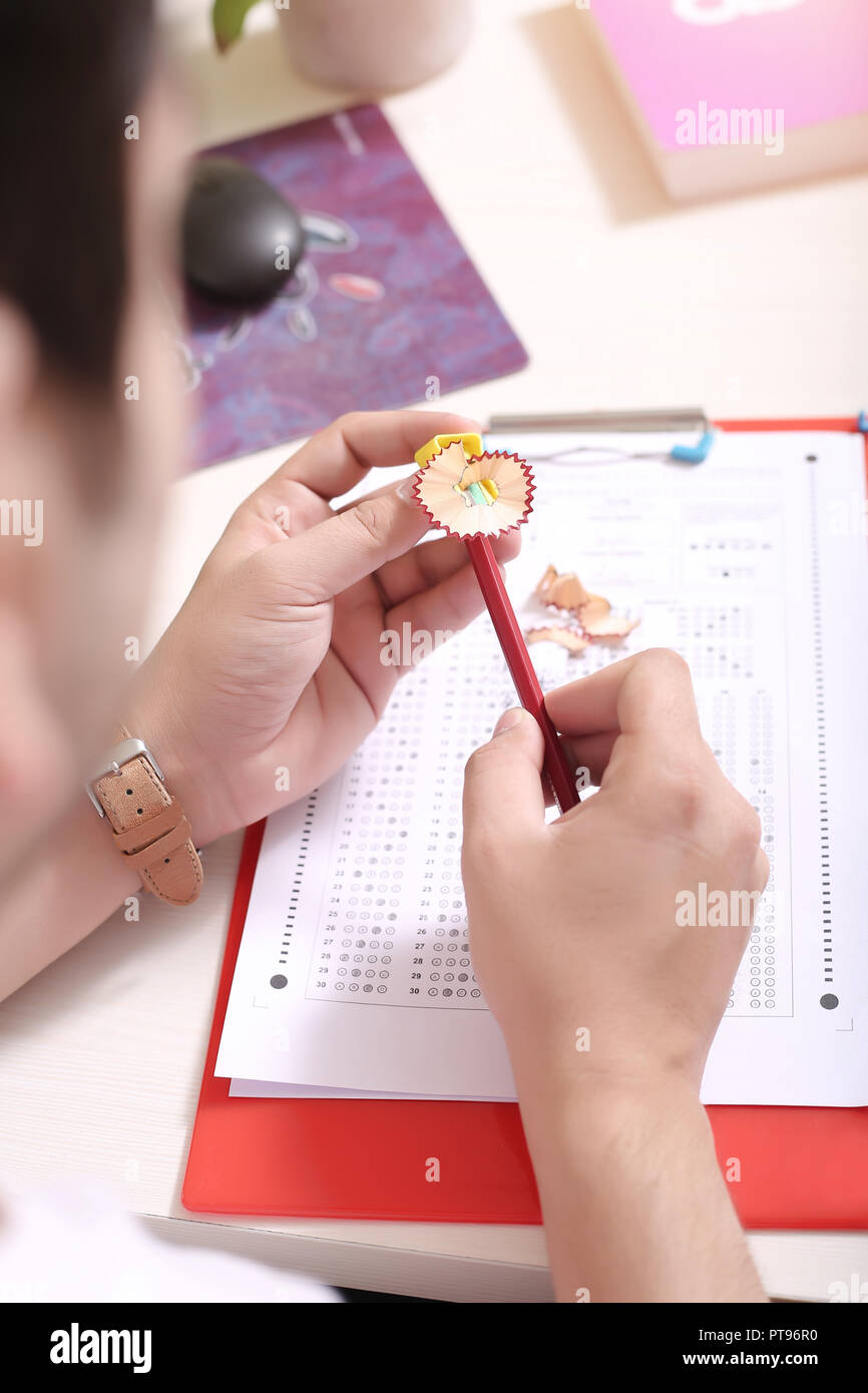 Man sharpening pencil with the help of sharpener. Picture of OMR sheet ...