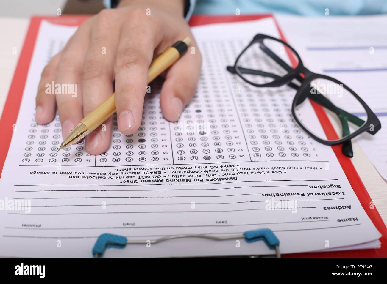 Picture of hand with pen and glasses on the OMR sheet. Photo of OMR ...