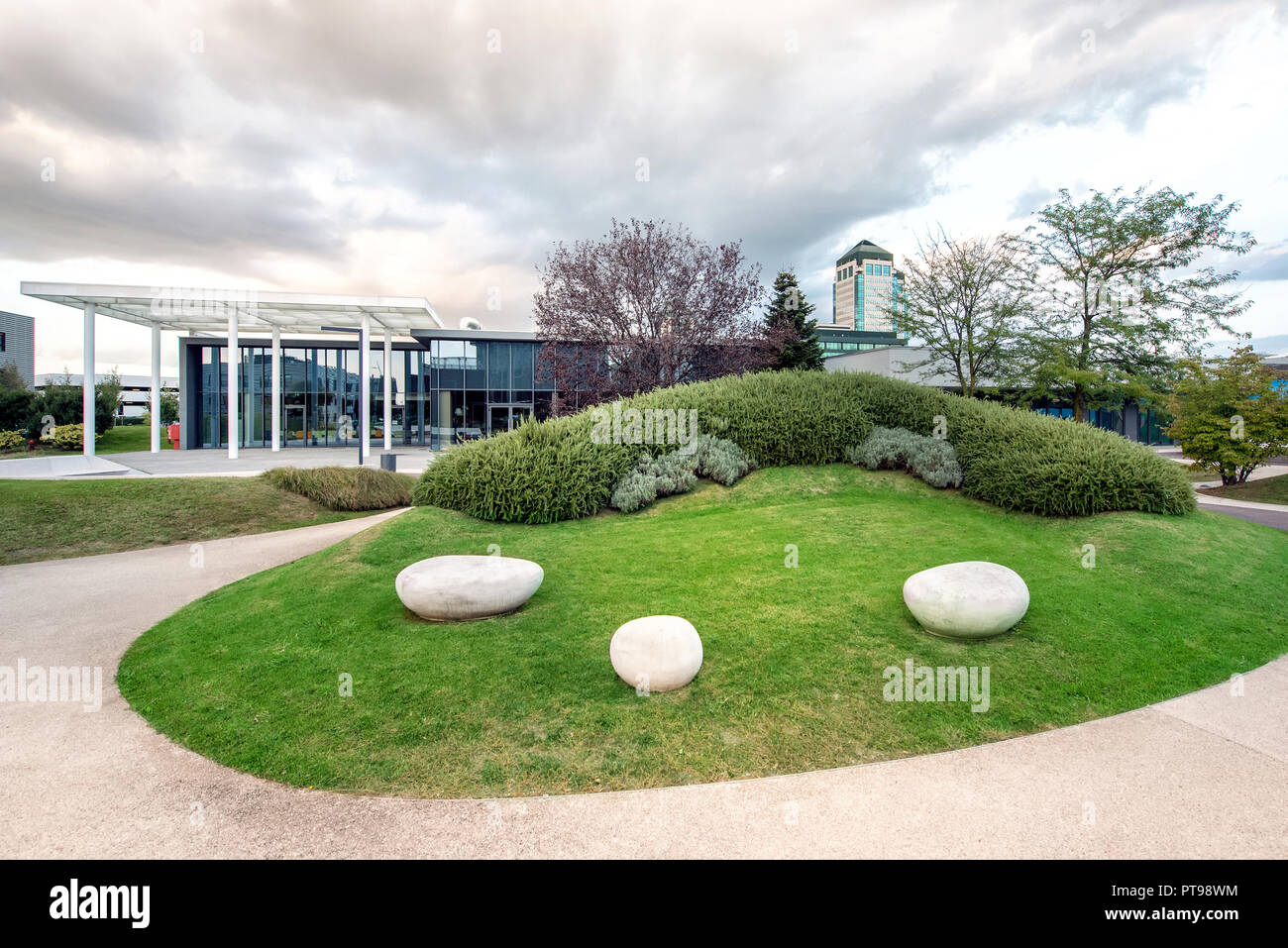 Landscaped traffic island by road outside modern building Stock Photo ...