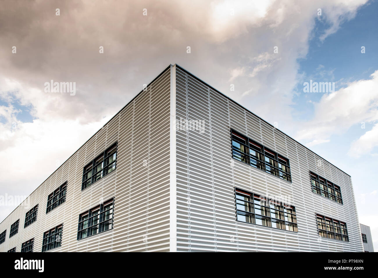 Exterior of modern office building viewed from corner with cloudscape ...