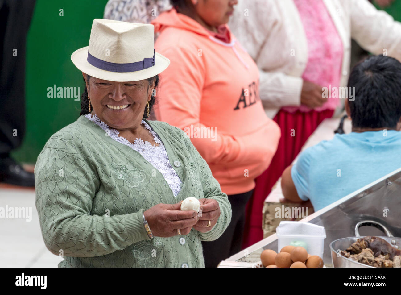 Chola woman in traditional hat preparing eggs Gualaceo indoor market nr ...