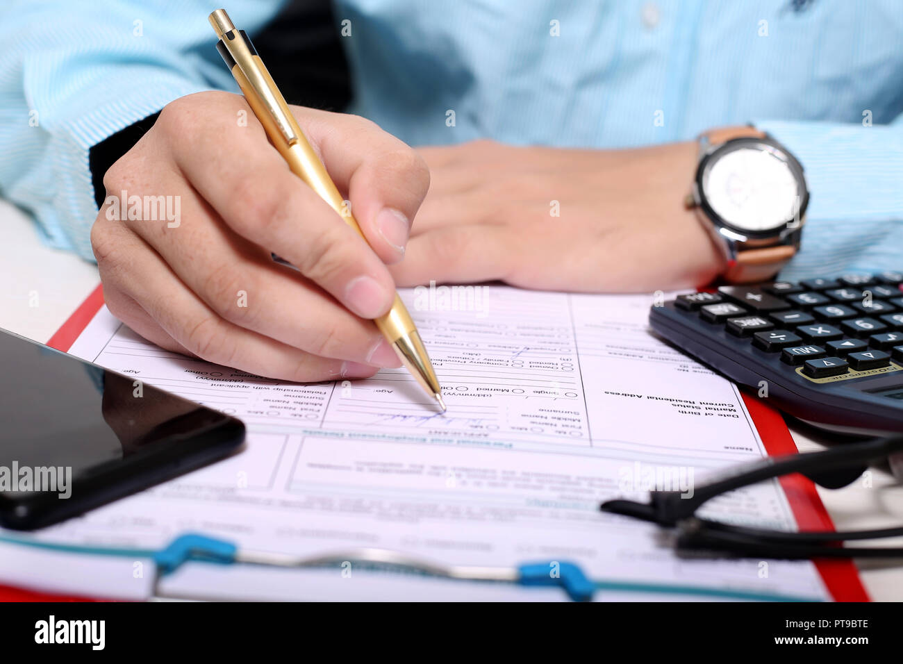 Man is filling form with pen. Picture of clipboard, form, glasses ...