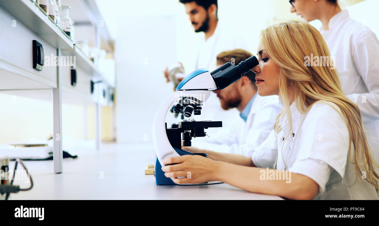 Young scientist looking through microscope in laboratory Stock Photo ...