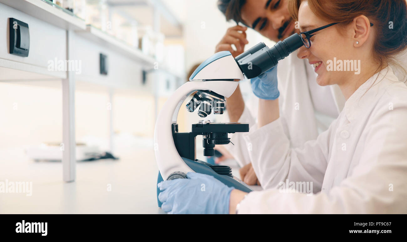 Young scientist looking through microscope in laboratory Stock Photo ...