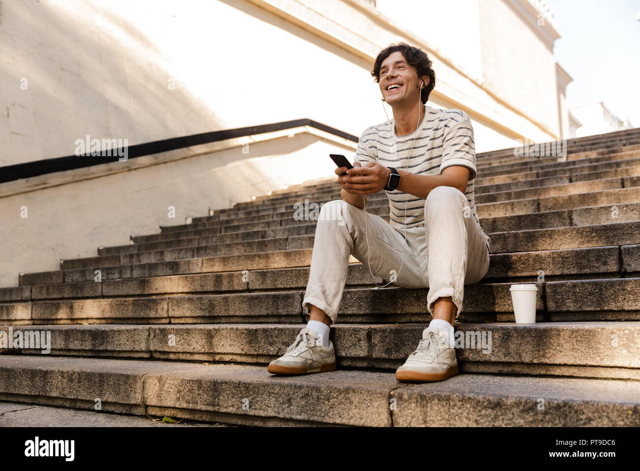 Young man sitting on steps hi-res stock photography and images - Alamy