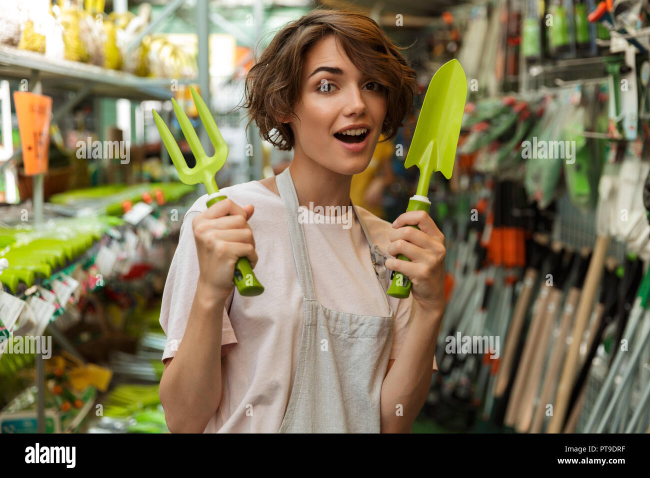 Image of beautiful cute woman gardener standing over plants in ...