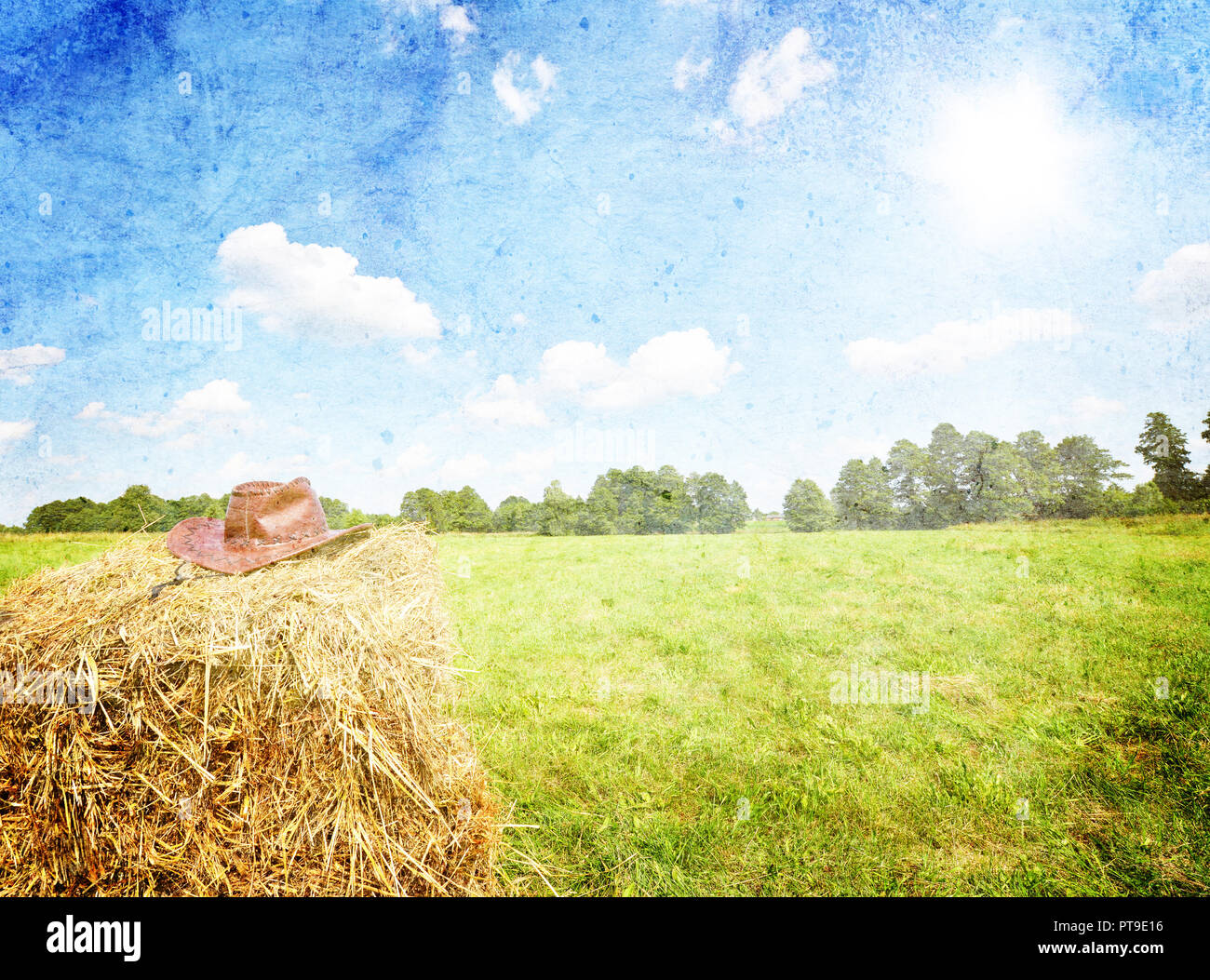 Summer landscape with cowboy hat on haystack Stock Photo - Alamy