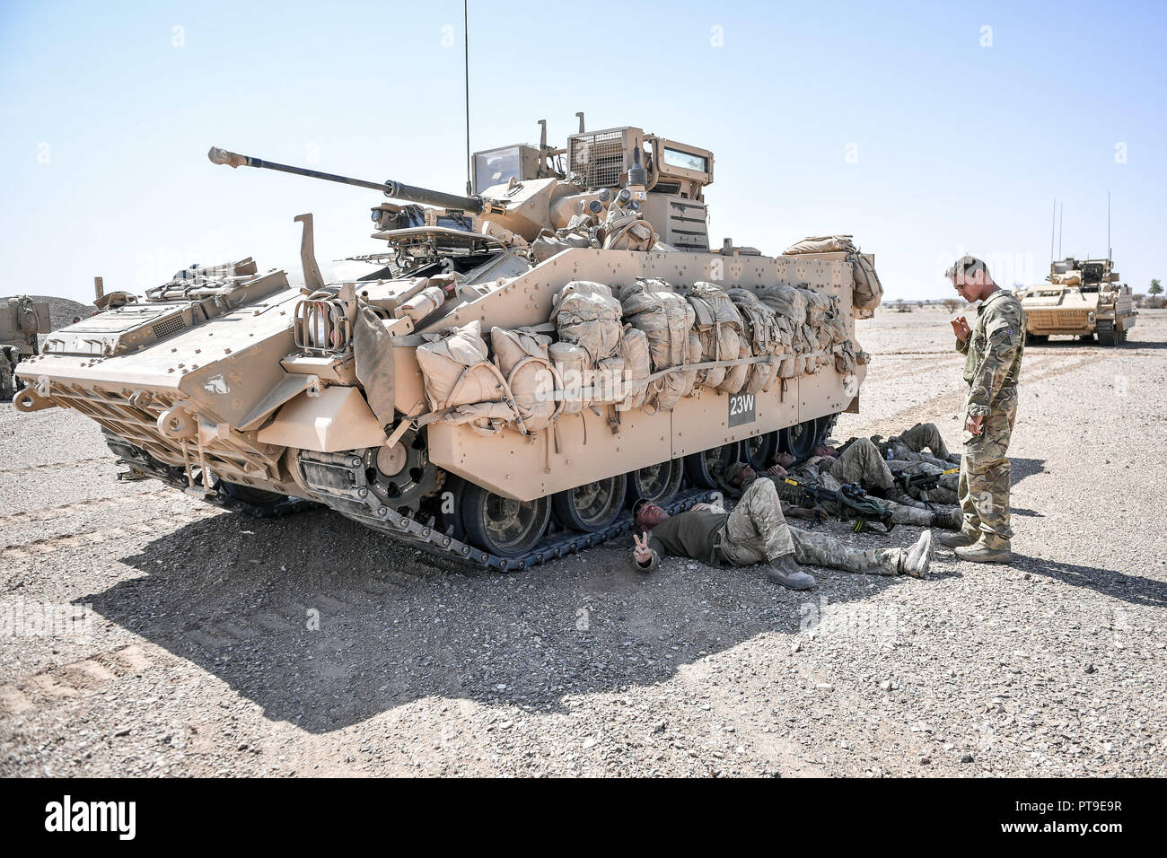 A Warrior armoured fighting vehicle crew take shade from the searing ...