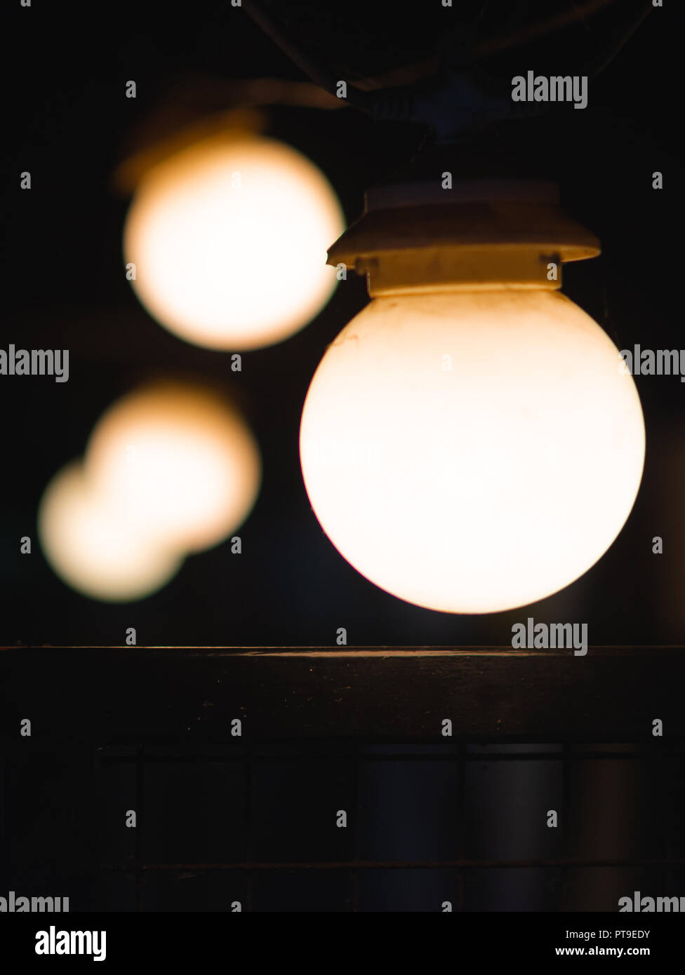 A series of 4 light bulbs in a line on a dark background Stock Photo ...