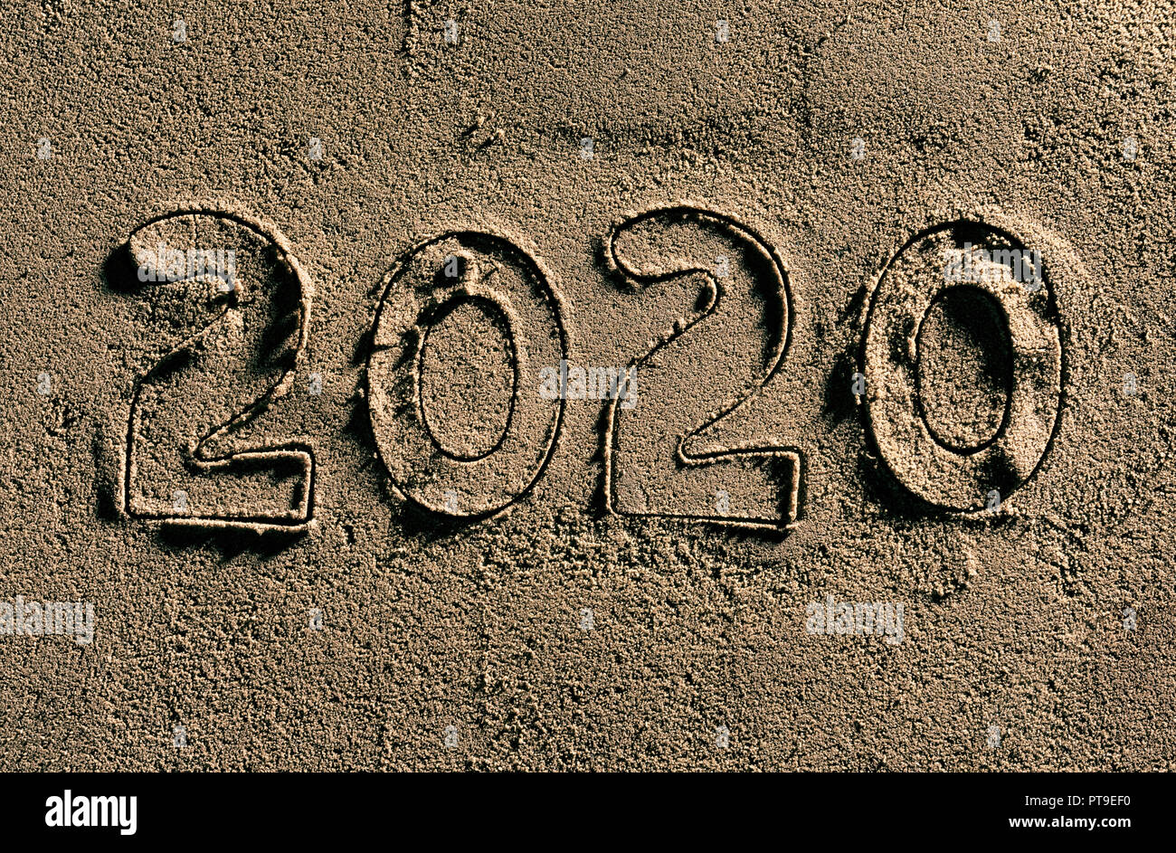 The year 2020 cut into wet sand Stock Photo - Alamy