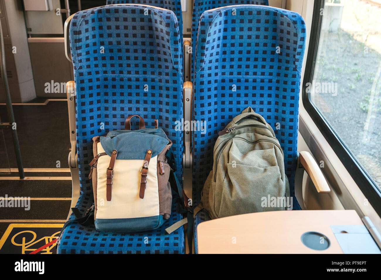 Tourist concept. Two backpacks on the seats in the train Stock Photo ...