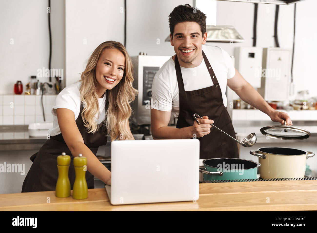 Image of cheerful emotional young friends loving couple chefs on the ...