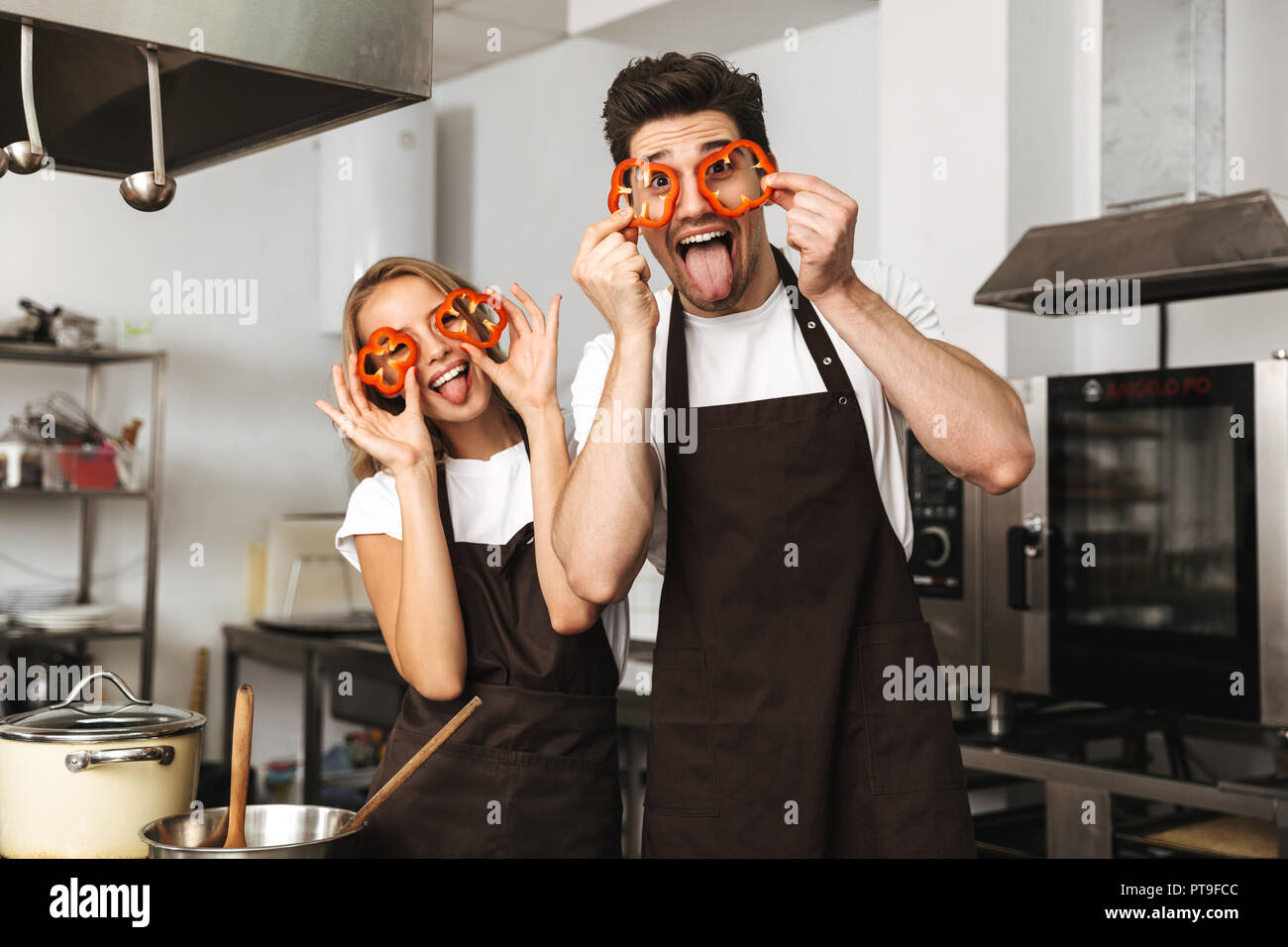 Image of smiling excited young friends loving couple chefs on the ...