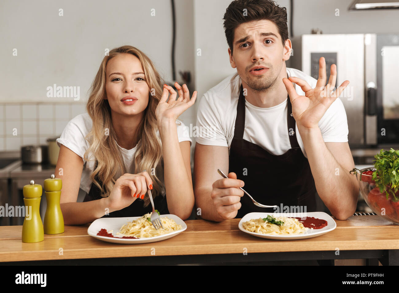Image of emotional excited young friends loving couple chefs on the ...