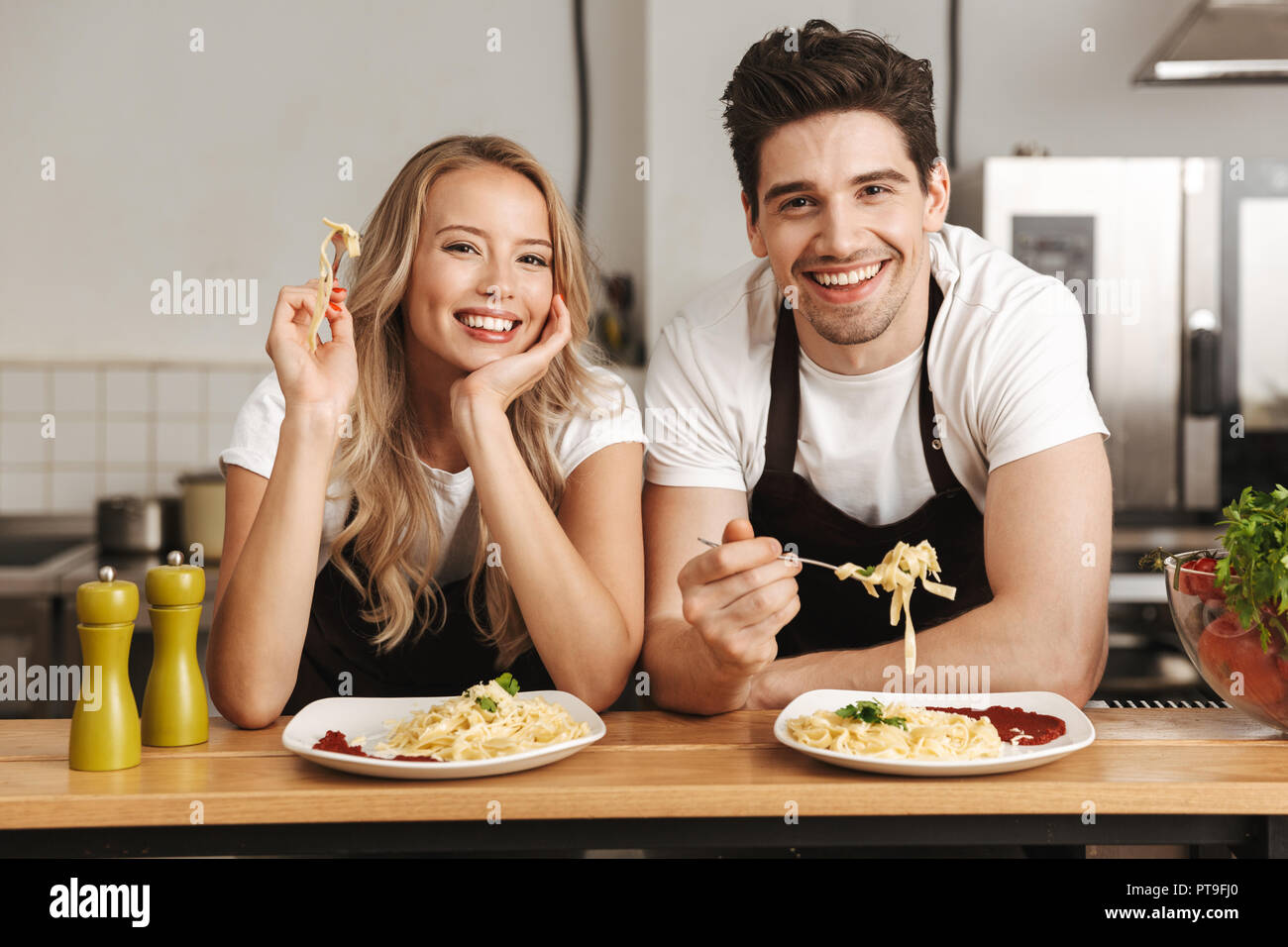 Image of emotional excited young friends loving couple chefs on the ...