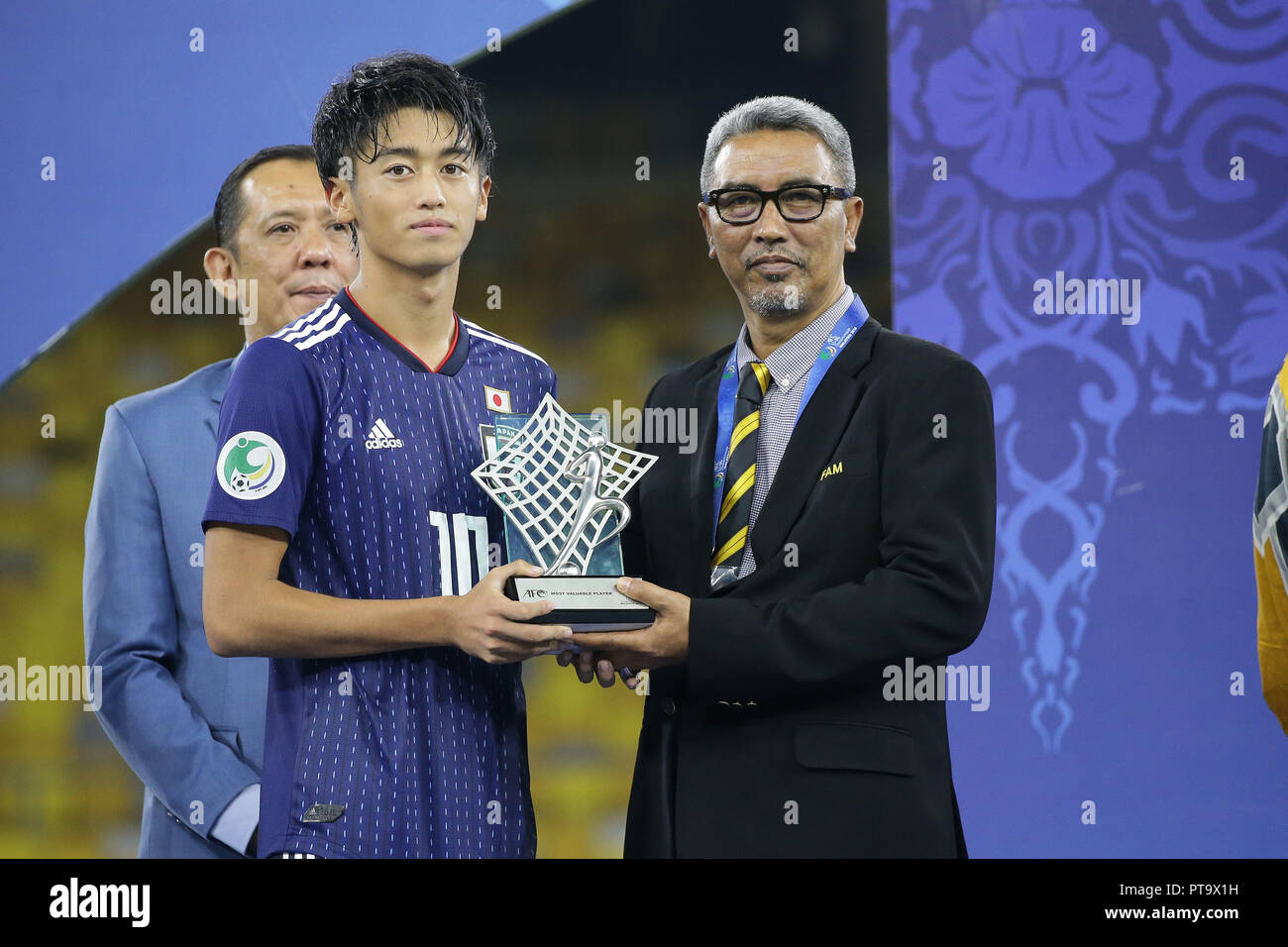 Japan's Jun Nishikawa (L) receives the Most Valuable Player's trophy ...