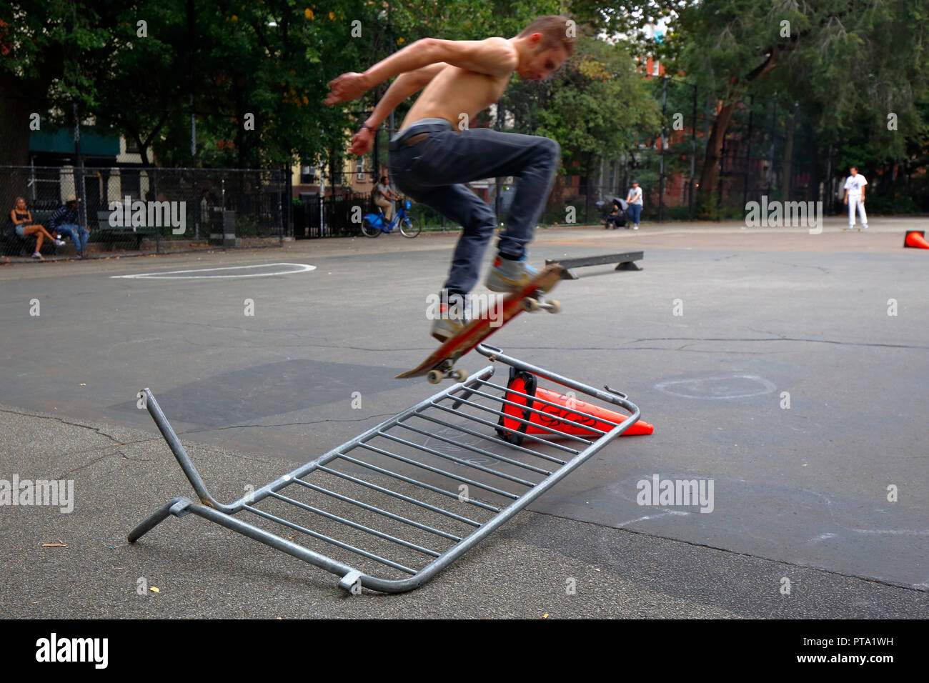 A Skateboarder ollies (jumps) over an overturned police barricade Stock ...
