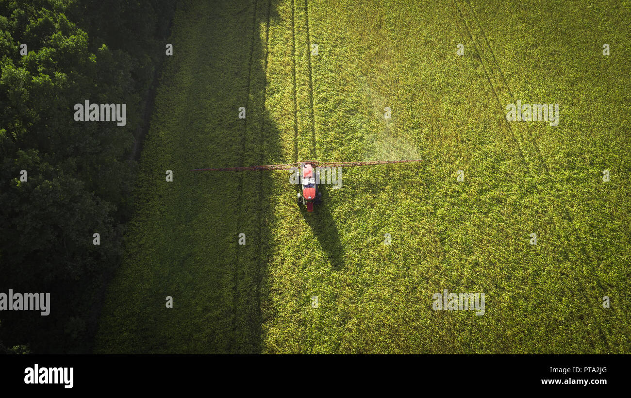 Agricultural machinery in the field. Tractor with a sprayer. Aerial ...