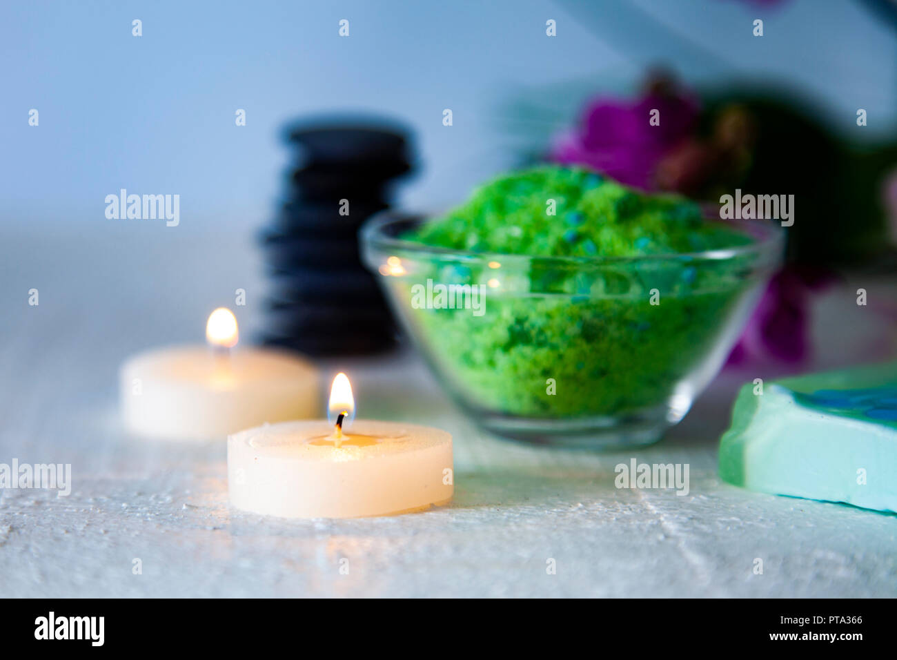 Spa treatments on wooden table. Sea salt, spa stones, orchid and ...