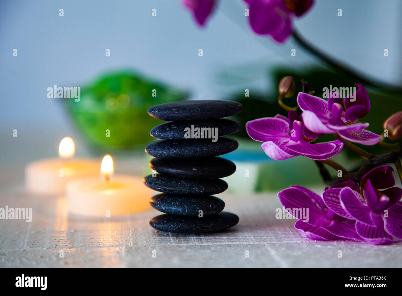 Spa treatments on wooden table. Sea salt, spa stones, orchid and ...