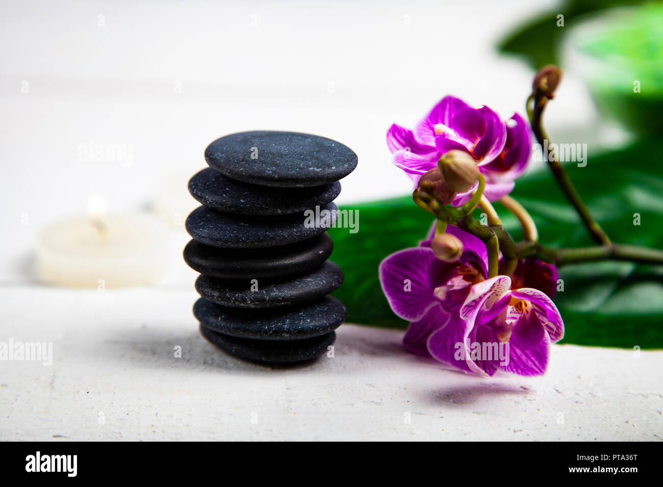 Spa treatments on wooden table. Sea salt, spa stones, orchid and ...
