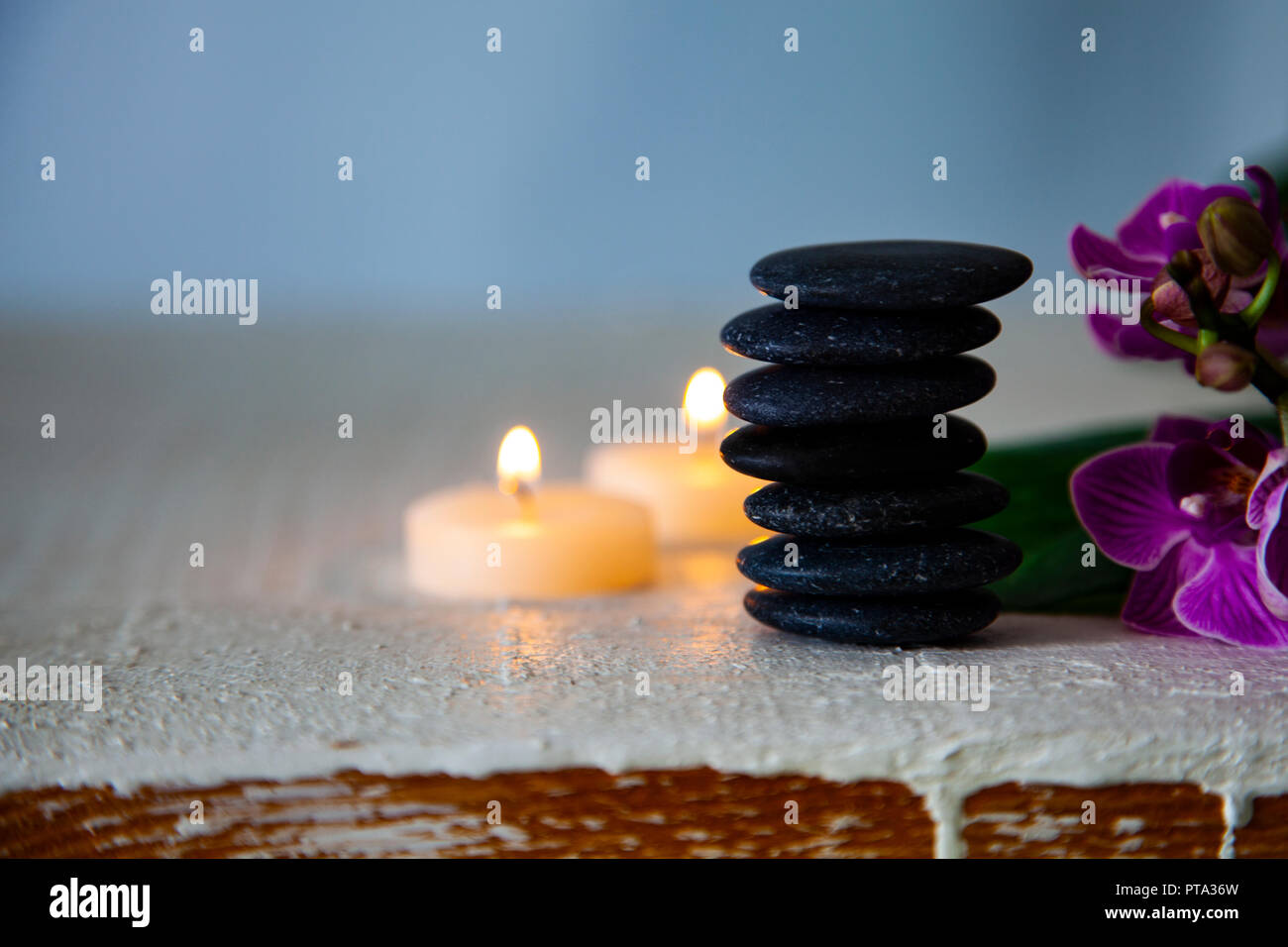 Spa treatments on wooden table. Sea salt, spa stones, orchid and ...
