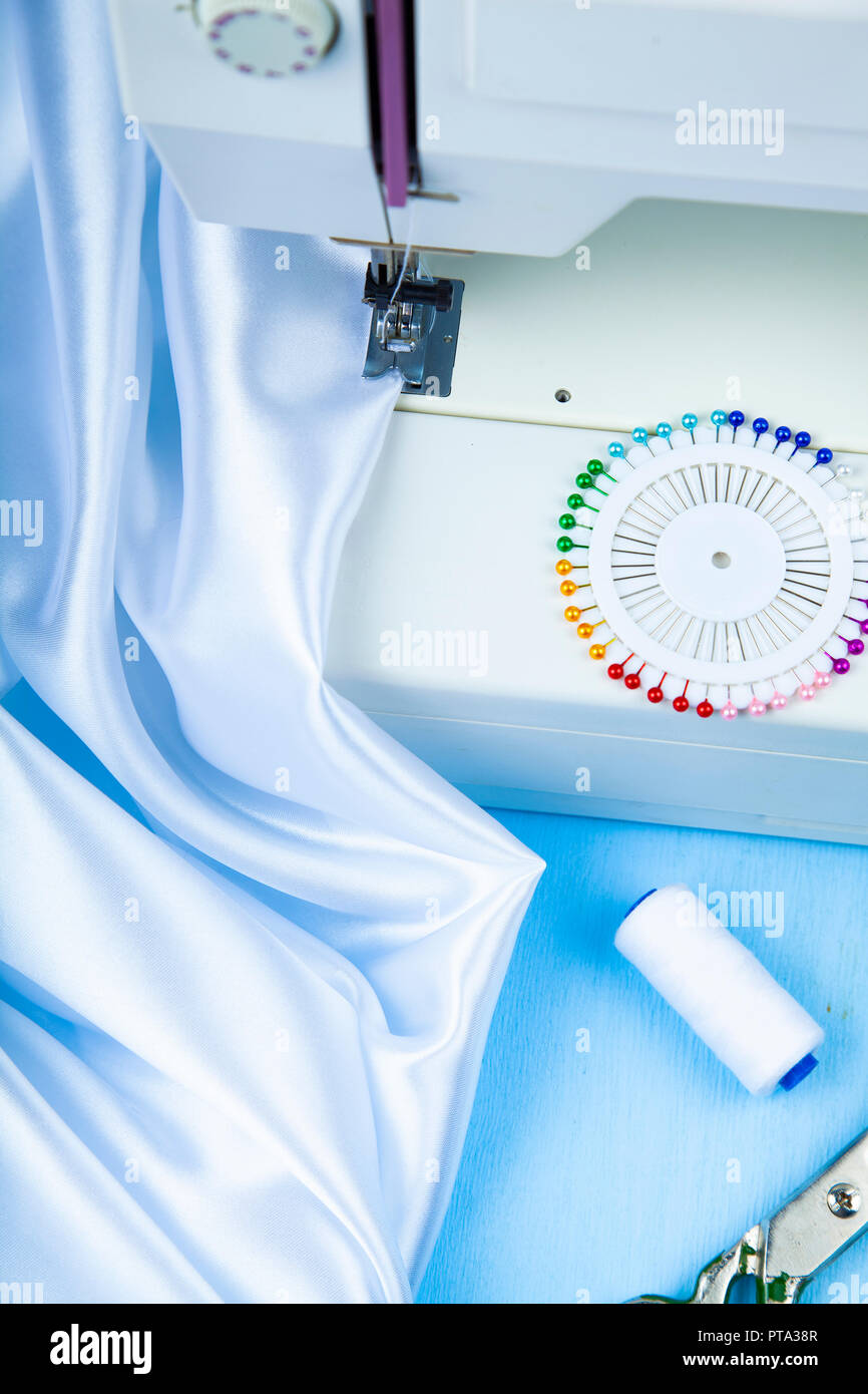 Sewing machine and white satin fabric close-up Stock Photo - Alamy