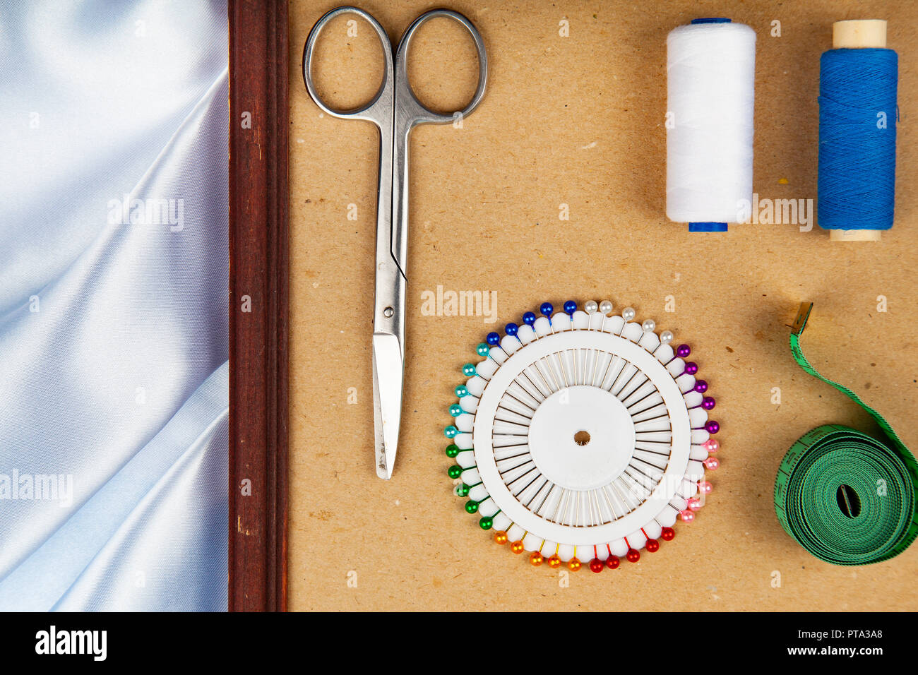 Sewing accessories in a frame on a white satin fabric Stock Photo - Alamy