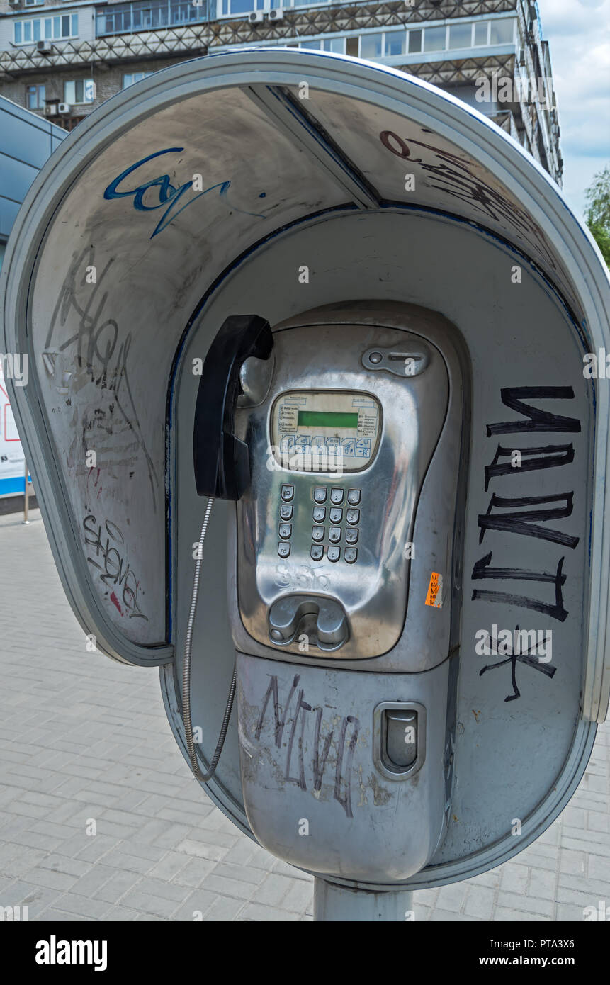 Painted and vandalized public payphone on roadside on the city street ...