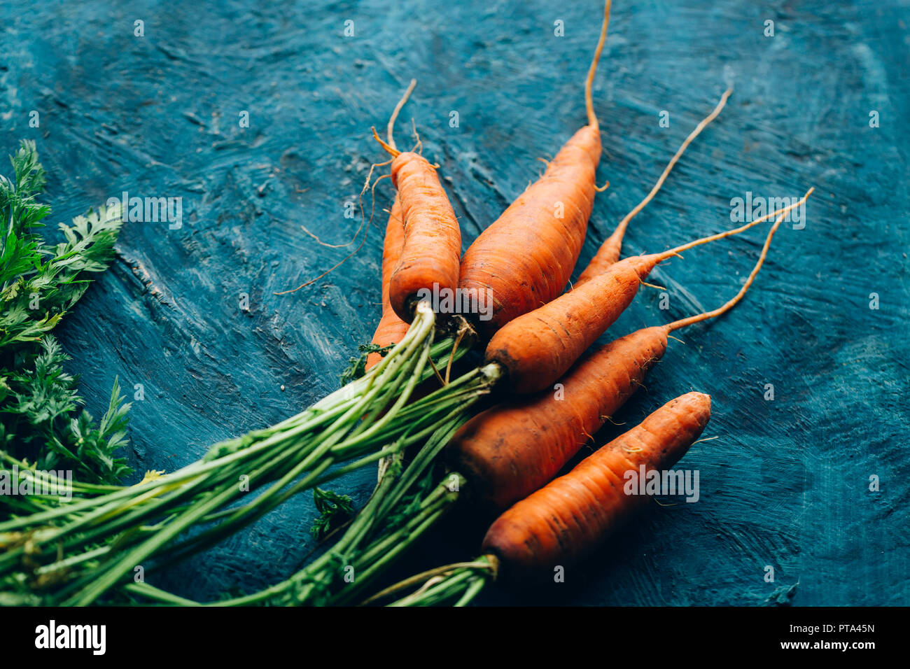 Fresh carrots on a blue wooden background Stock Photo - Alamy