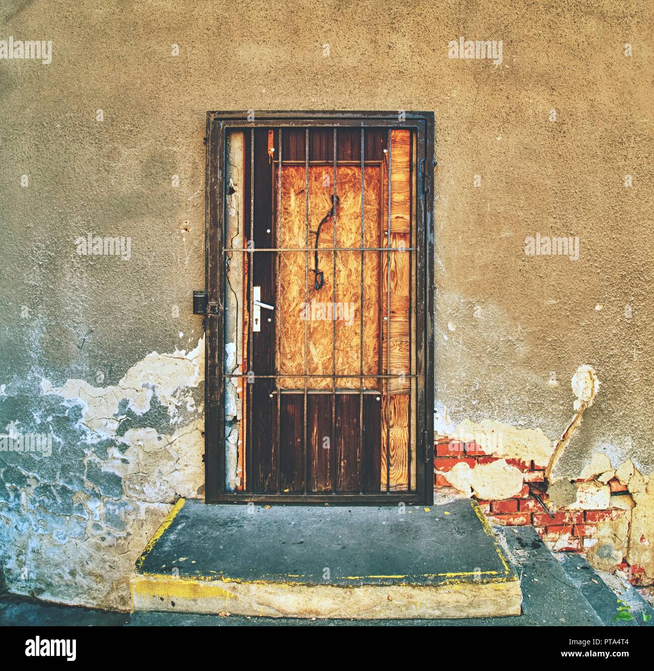 Walled door entry of abandoned house. Broken iron bars over door hole ...