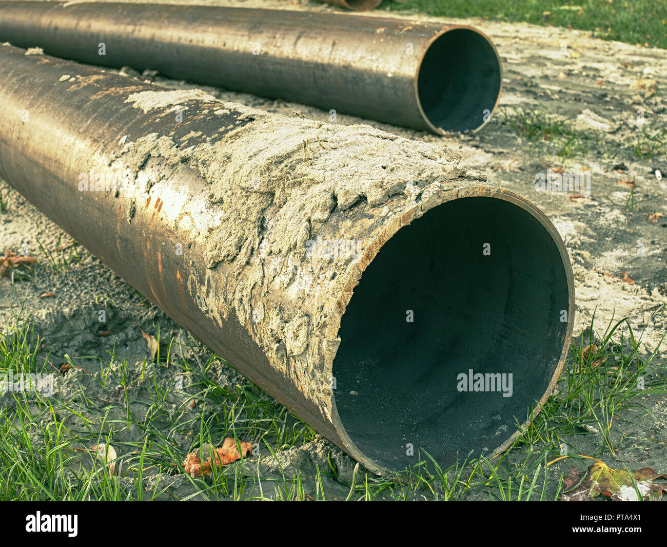 Long metal industrial pipes laying on ground. Repairing of the water ...