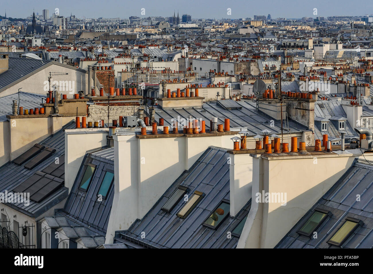 The roofs of Paris and its chimneys under a clouds sky, France, Europe ...