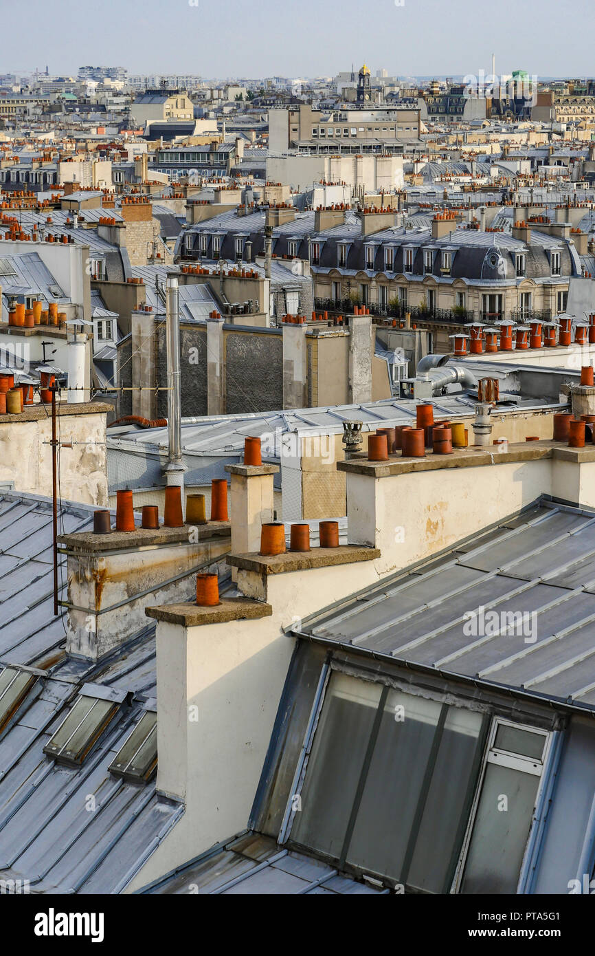 The roofs of Paris and its chimneys under a clouds sky, France, Europe ...