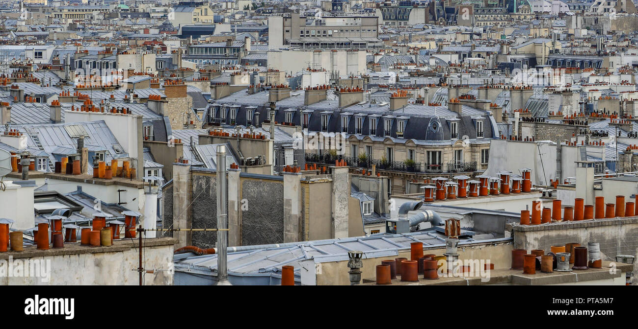 The roofs of Paris and its chimneys under a clouds sky, France, Europe ...