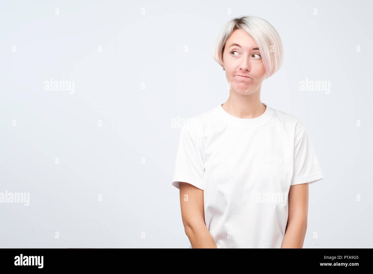 Worried confused girl with short colored hair and cute freckles ...