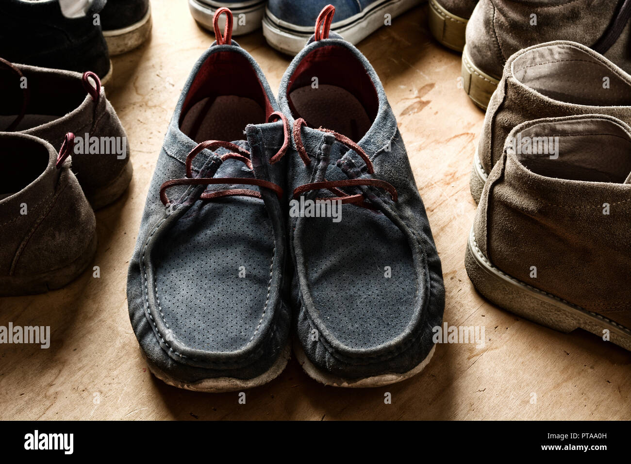 pile of men's shoes on wooden table - closeup Stock Photo - Alamy