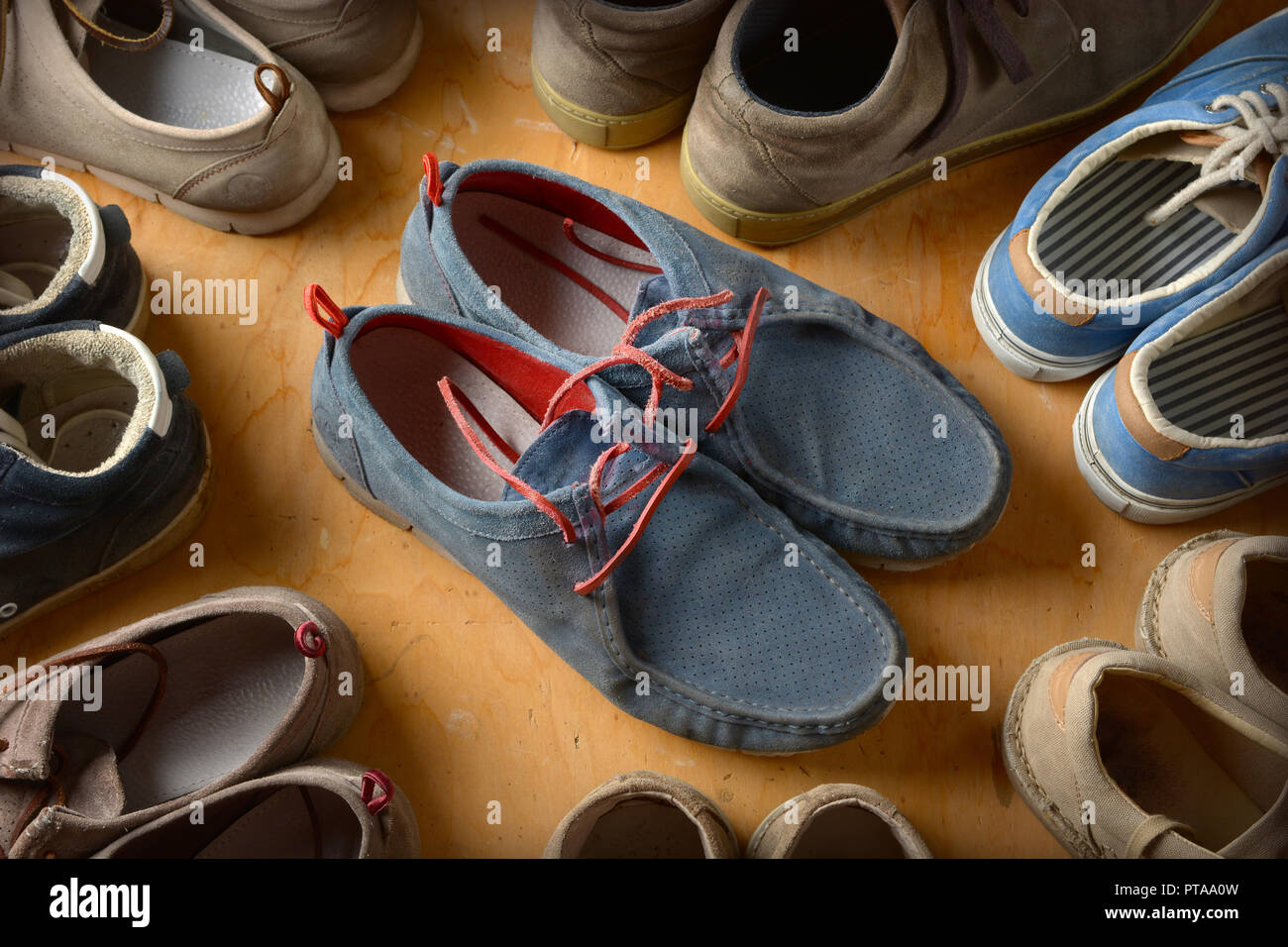 pile of men's shoes on wooden table - closeup Stock Photo - Alamy