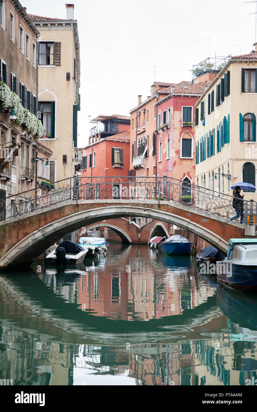 reflections in a canal waterway in Venice , Italy with bridges and ...