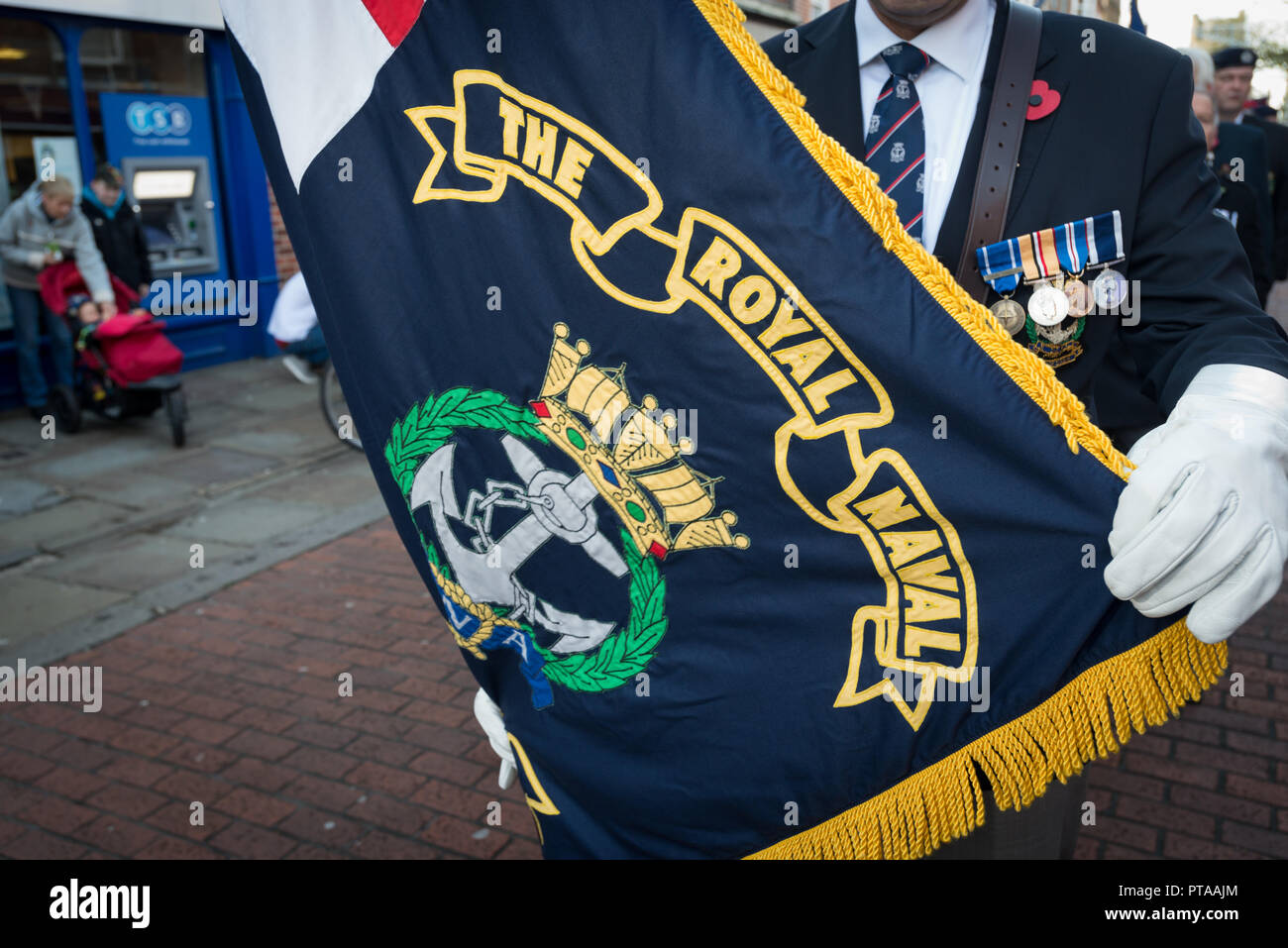 Remembrance Sunday parade, a royal navy veteran wearing medals holds a ...