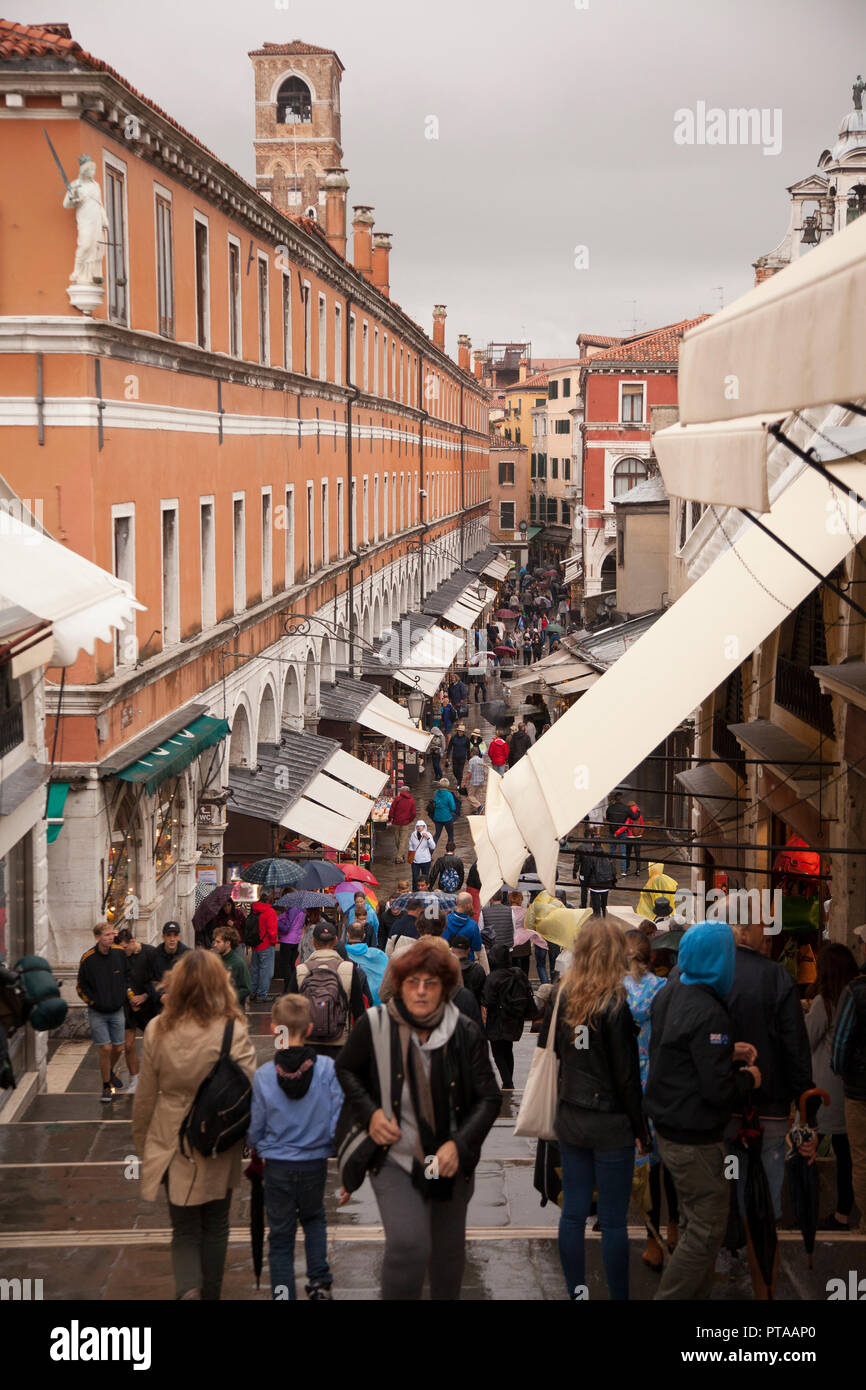 the narrow and busy streets of Venice, Italy with tourists and shoppers ...