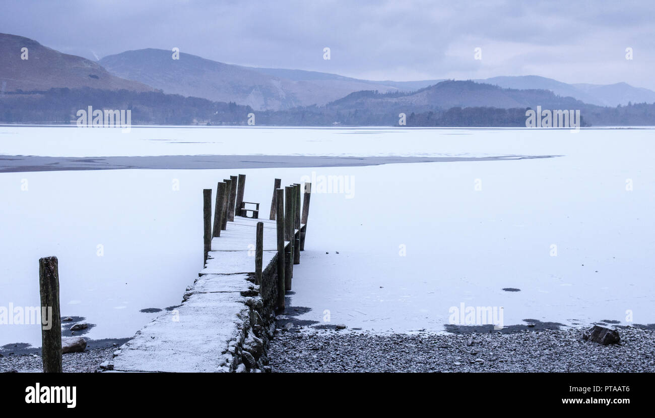 A wooden jetty stands in the frozen Derwent Water lake in the English ...