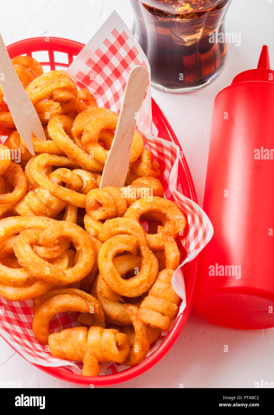 Curly fries fast food snack in red plastic tray with glass of cola and ...