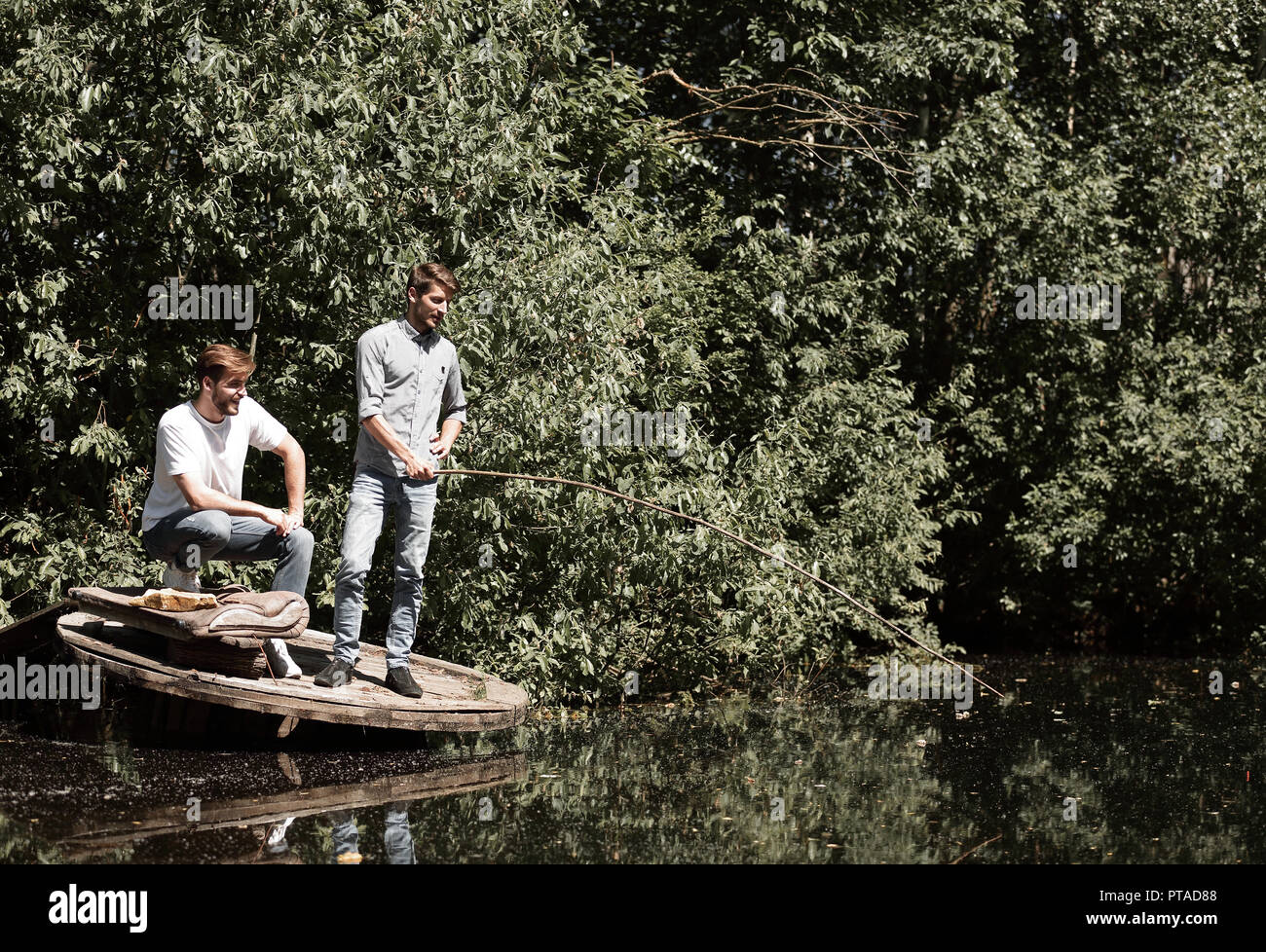 two friends are fishing on the lake in the early morning Stock Photo ...