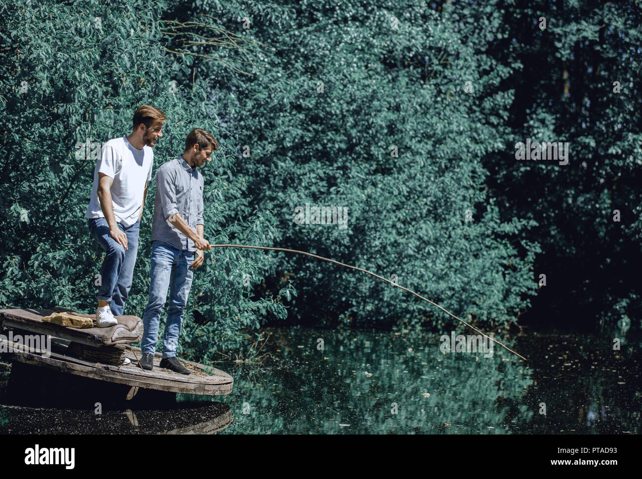 two friends are fishing on the lake in the early morning Stock Photo ...