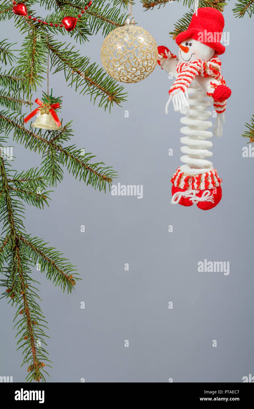 Branches of fir tree with figure of snowman, ball, bell and other ...